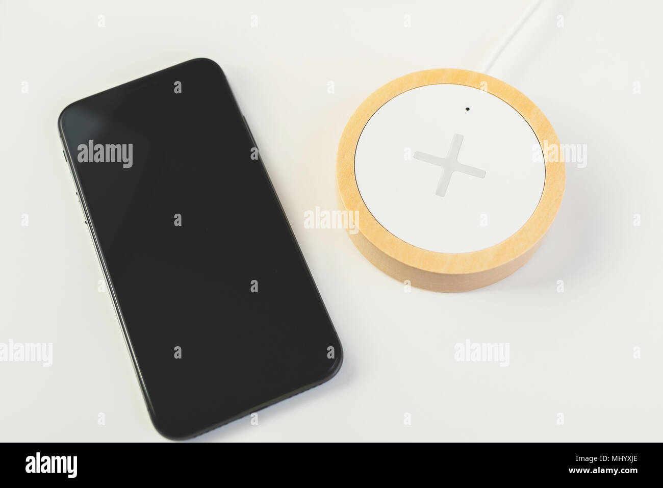 Mobile phone and wireless charger on office table. Future technology ...