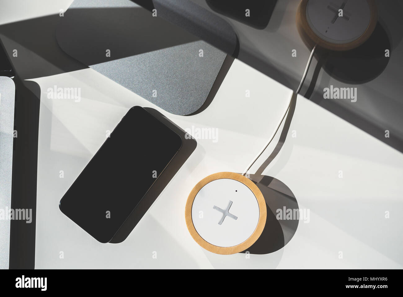 Mobile phone and wireless charger on office table. Future technology ...