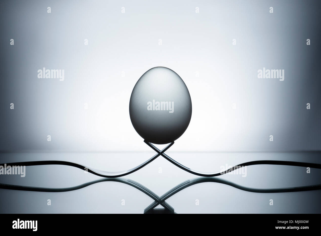 Balanced egg on two forks. Concept of teamwork, solidarity and unity ...