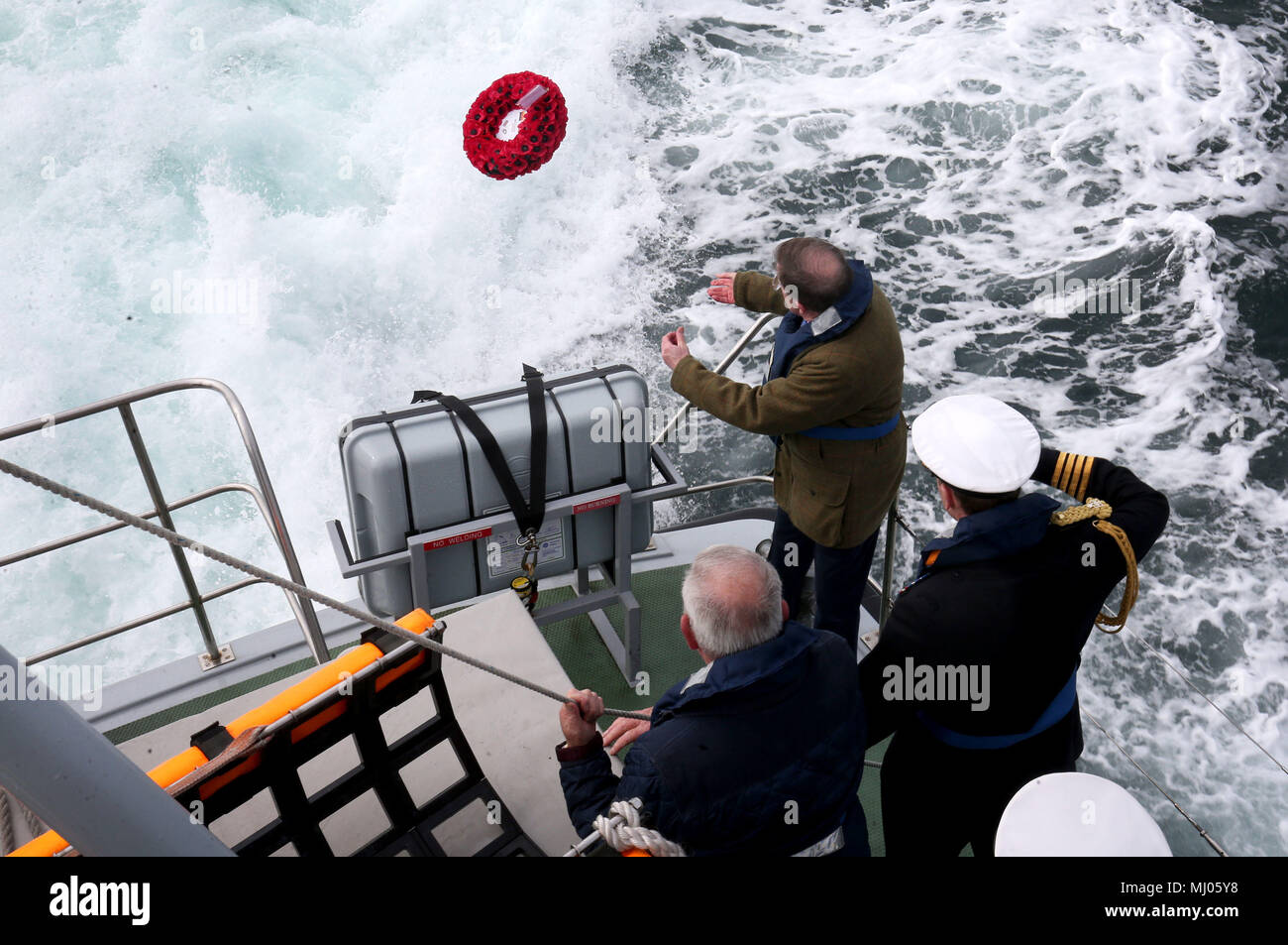 Lord George Robertson throws a wreath into the sea close to the wreck ...