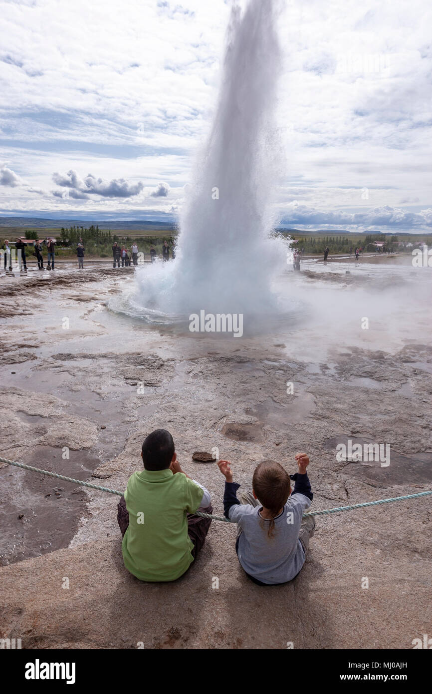 Two children enjoying the eruption of the geyser hi-res stock ...