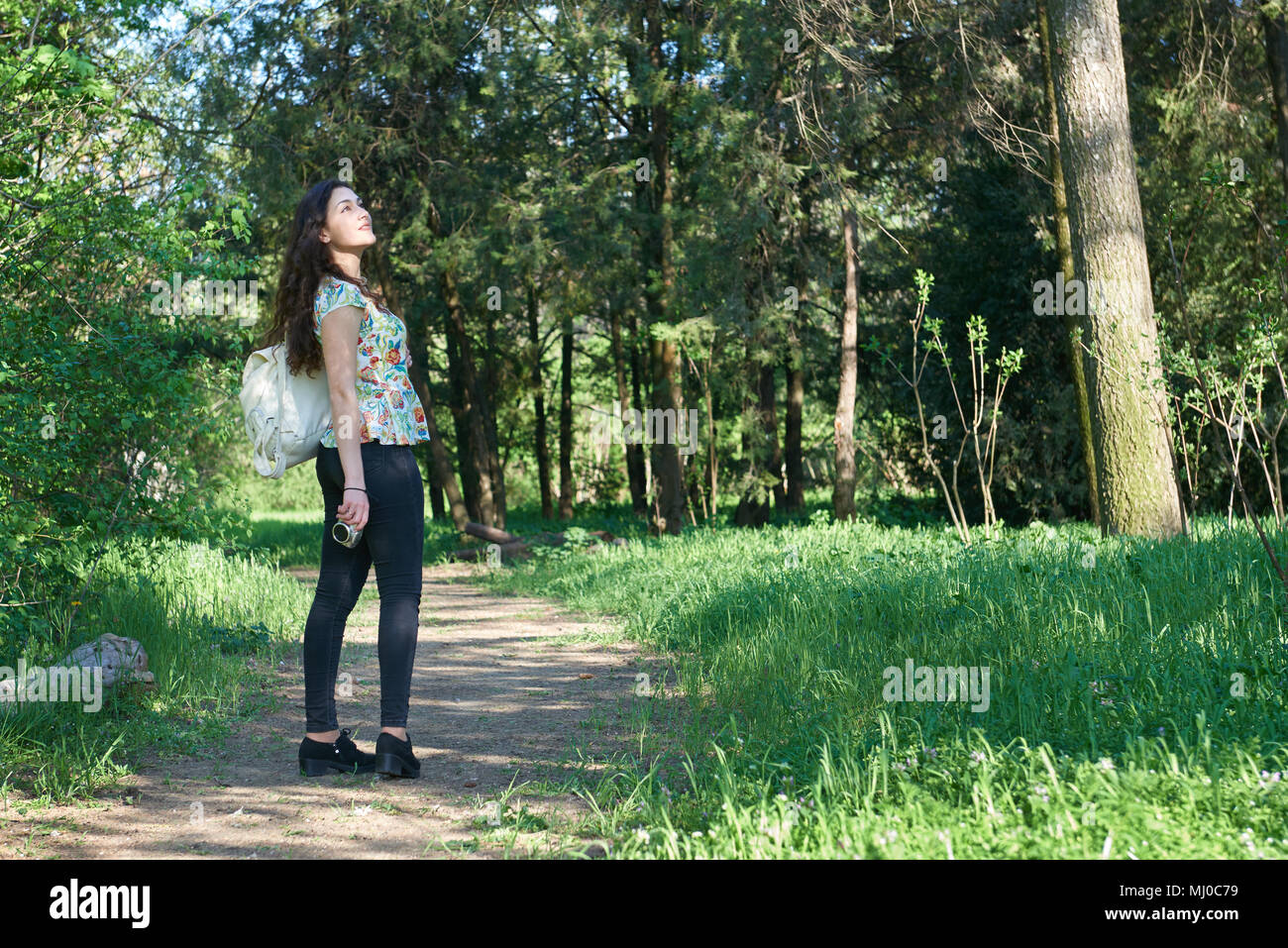 girl walking along a forest trail and taking pictures of nature Stock ...