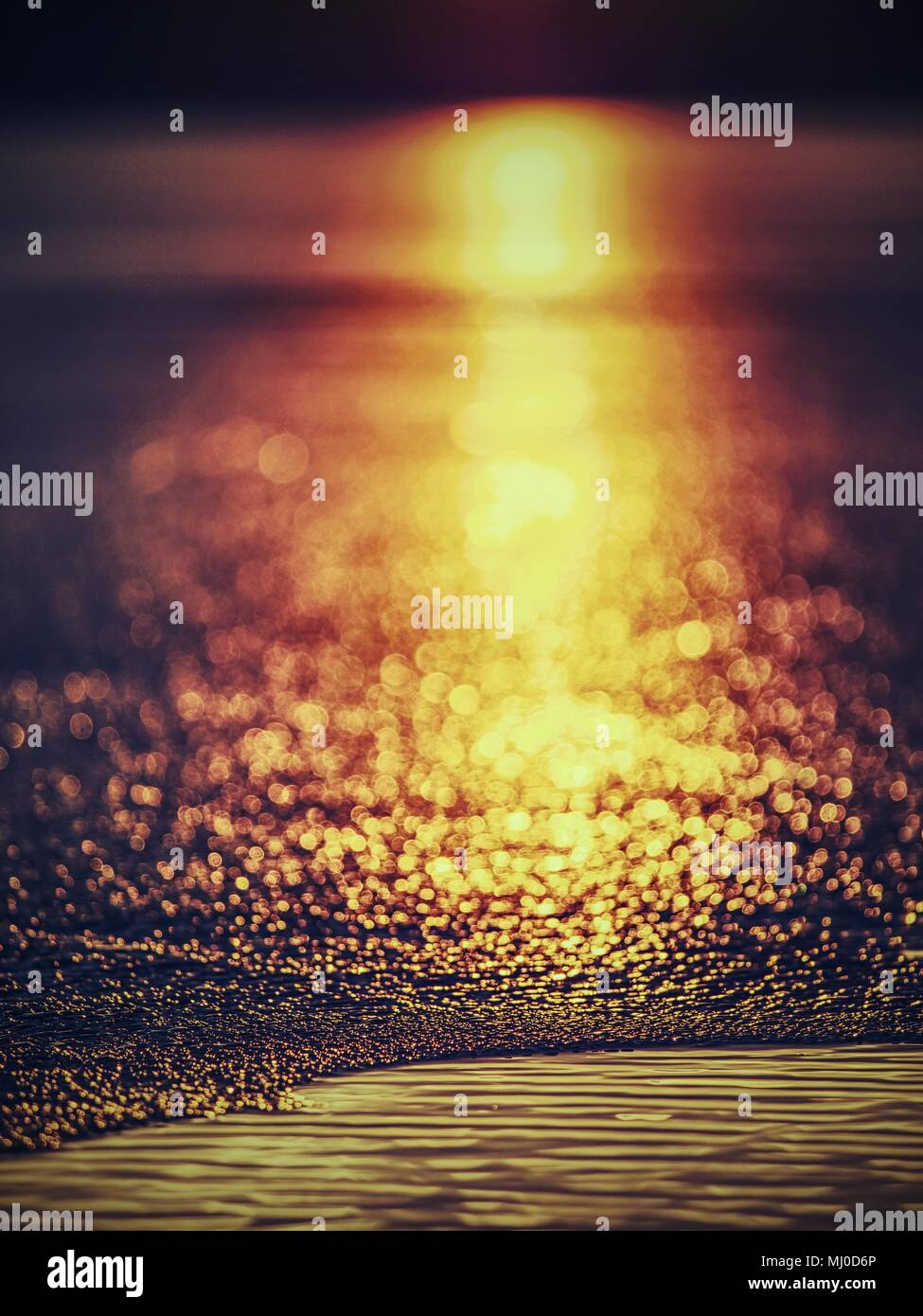 Sharp edge of dark water thawed from under the prurple blue ice in ...