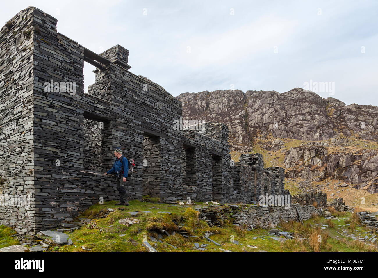 A hiker looks into the window of the ruined slate quarry buidings ...