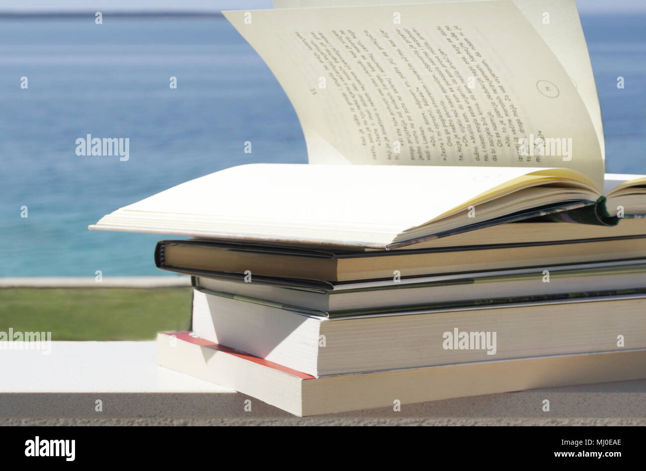 Few books in vertical line with open book on the top and pages turning ...