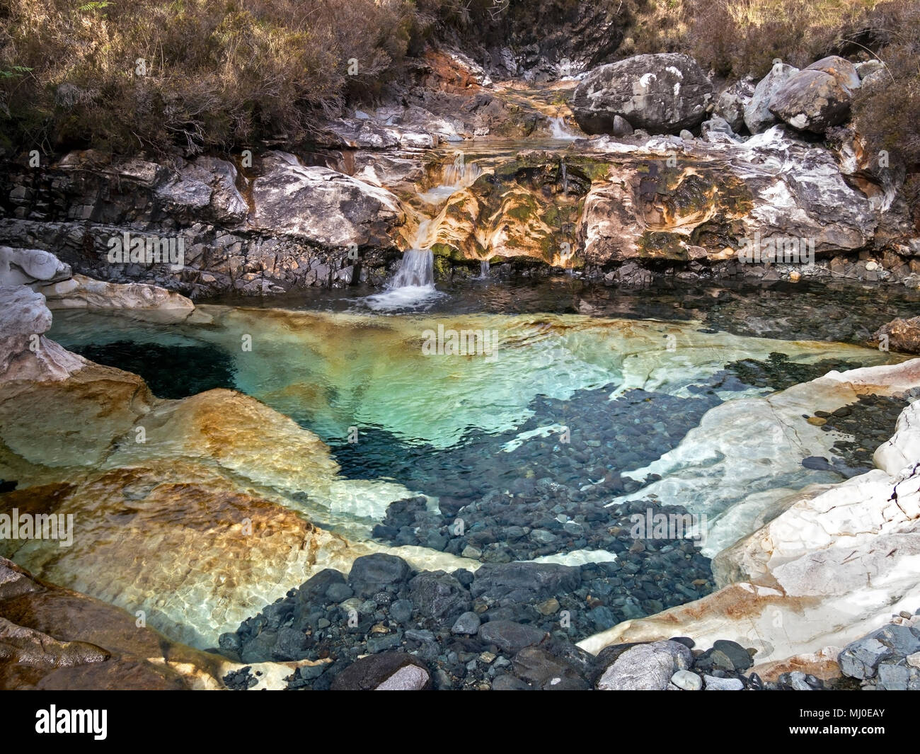 Rock pool eroded into Skye white marble slab in mountain stream bed of ...
