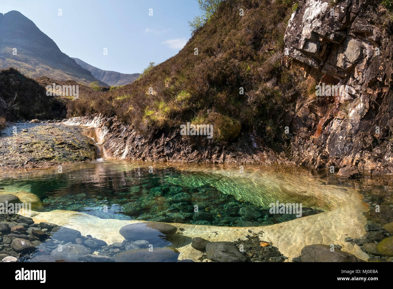 Rock pool eroded into Skye white marble slab in mountain stream bed of ...