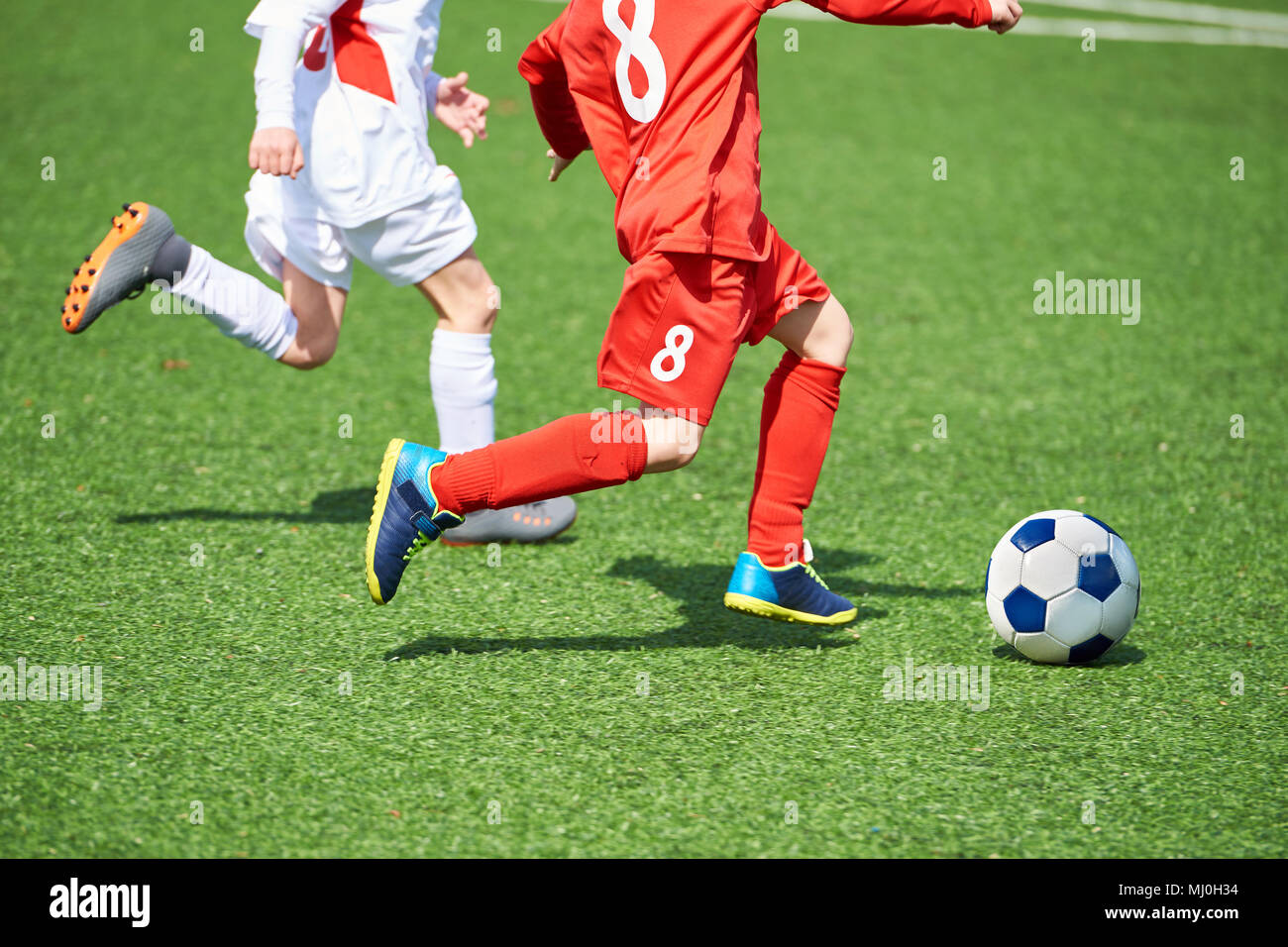 Child football players and ball on the football field Stock Photo - Alamy