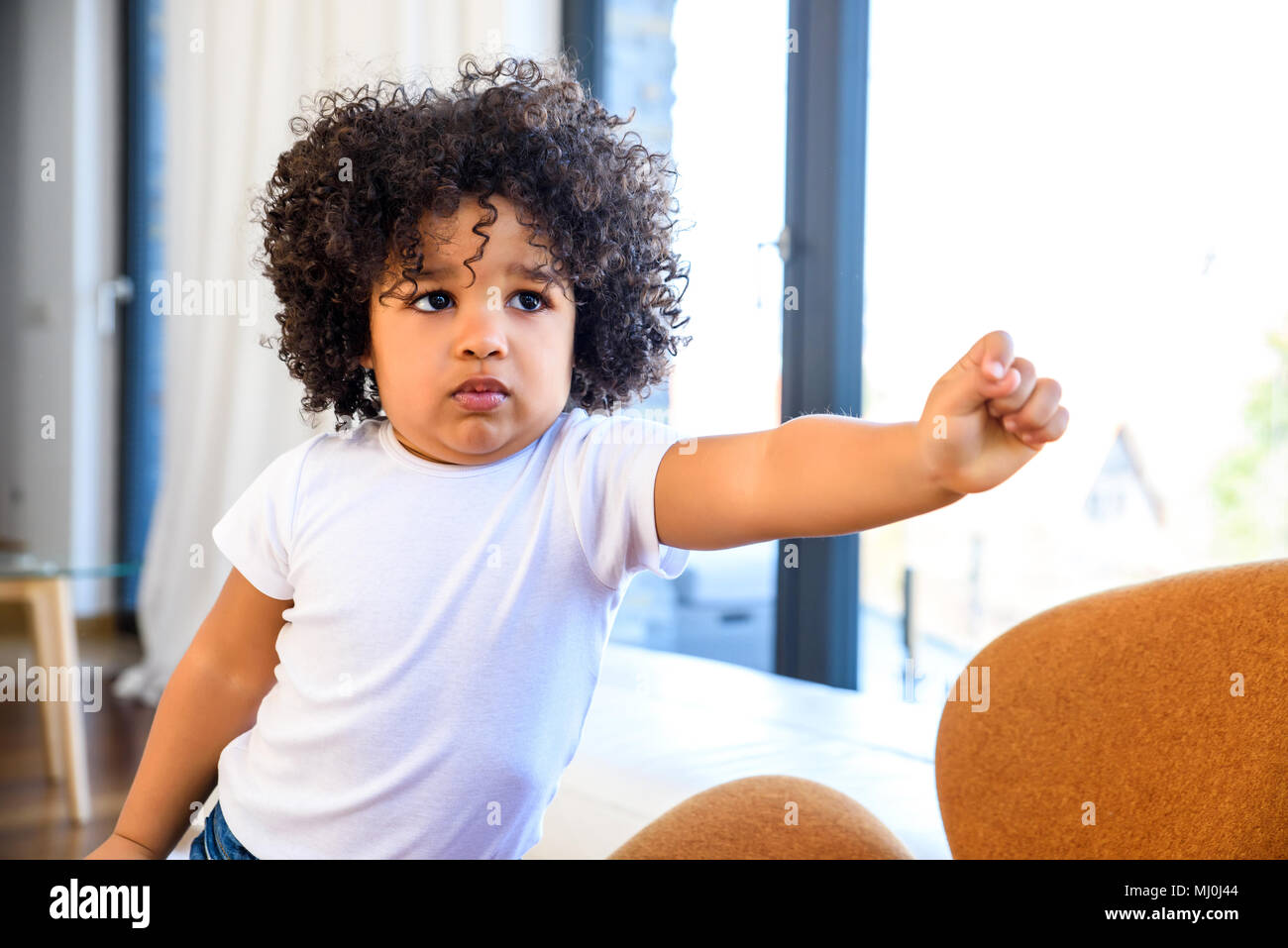 Portrait of a young afro child standing in a living room Stock Photo ...