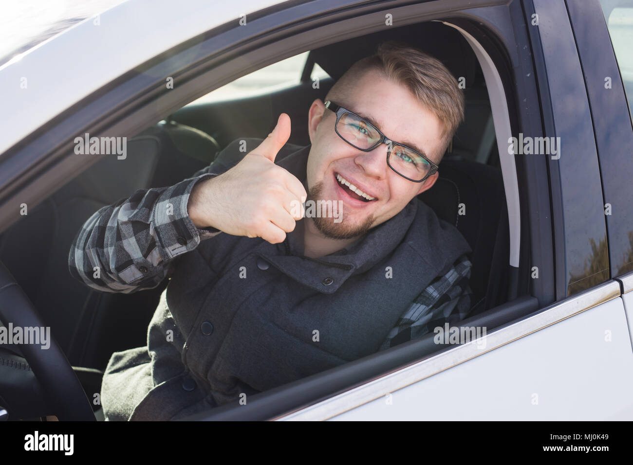 Young man test drive new car and showing thumbs up Stock Photo - Alamy