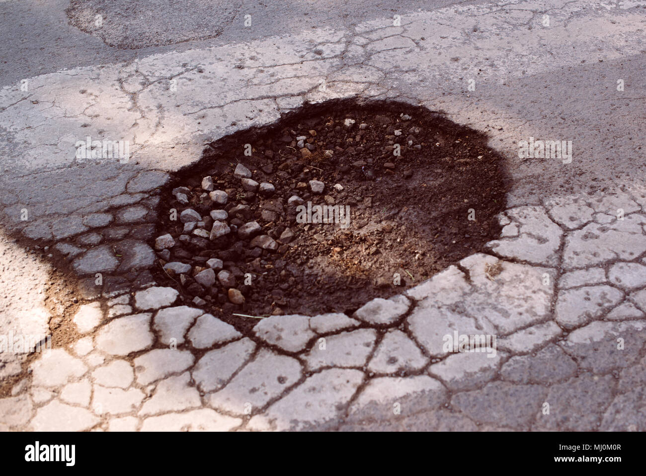 Pothole on the road, dangerous spot on driveway Stock Photo - Alamy