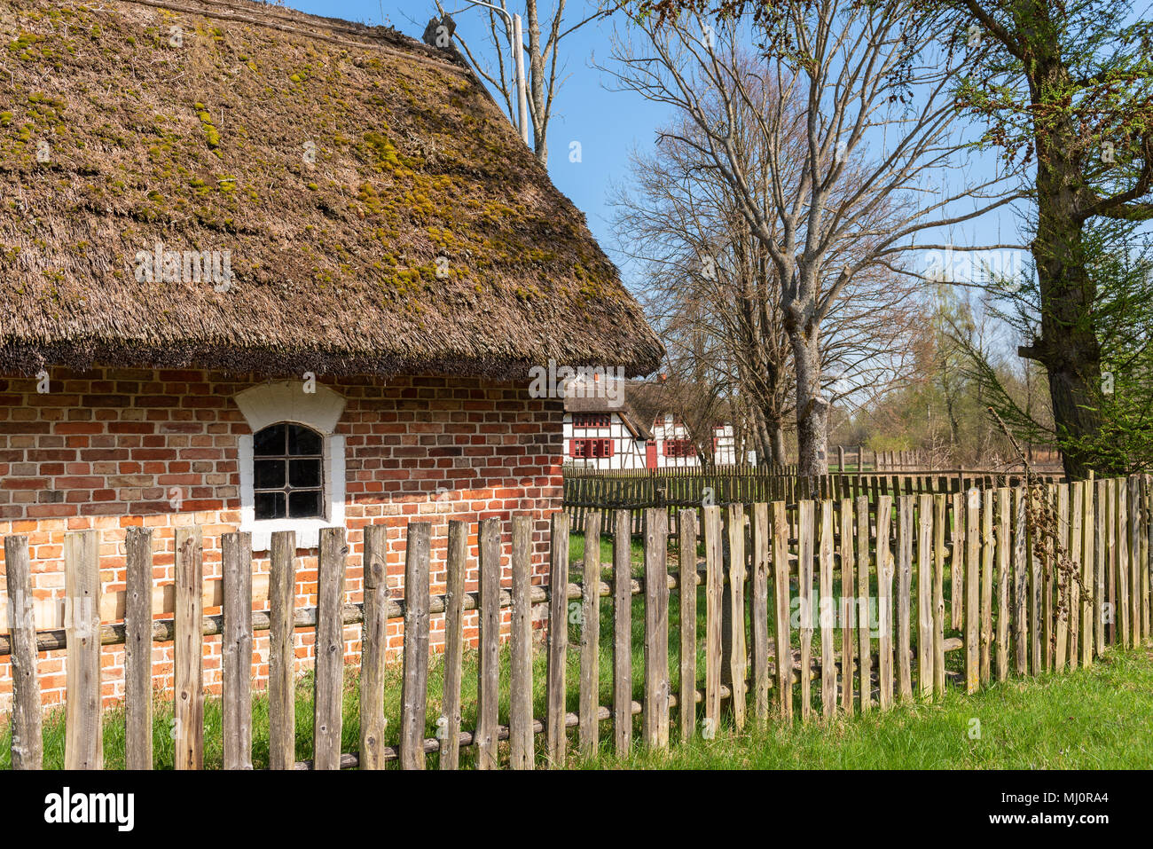 Wooden fence and traditional Polish country thatched house. Kluki ...