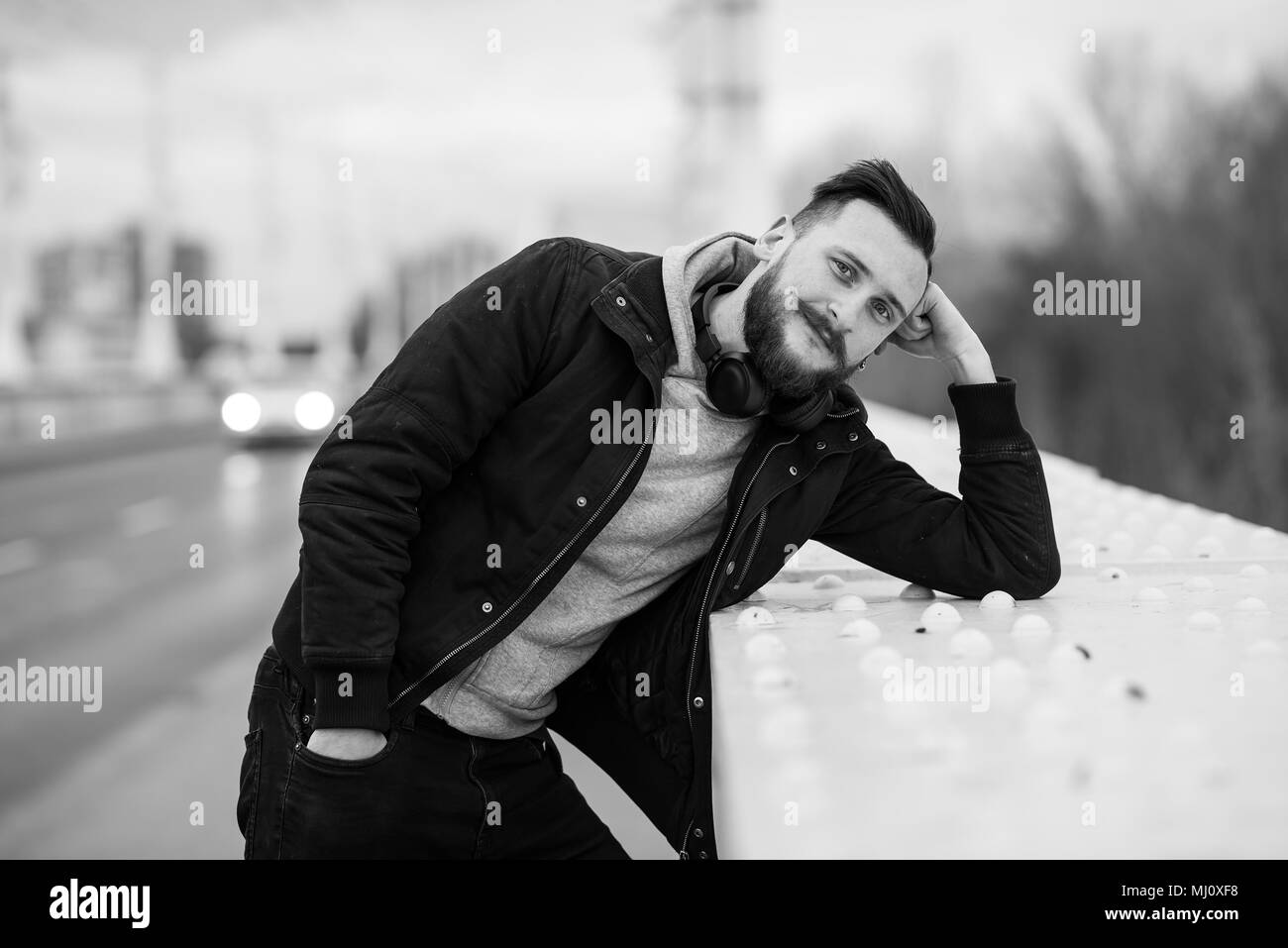 Portrait of a thinking handsome young hipster man while leaning on the ...