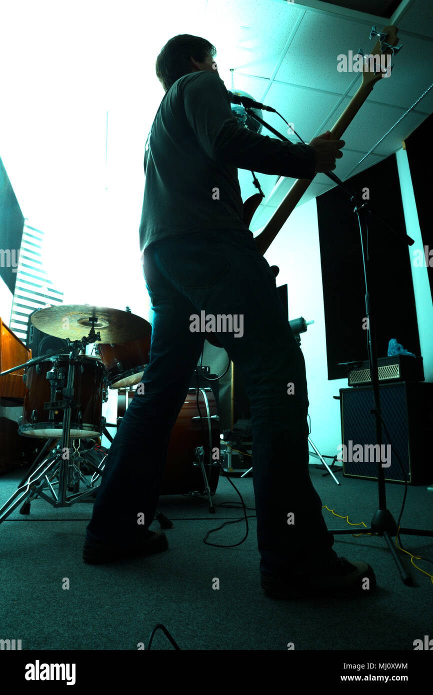 A Rock singer playing bass in the rehearsal Studio Stock Photo - Alamy
