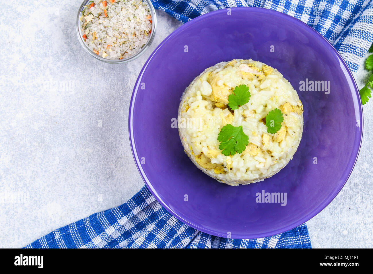 White steamed rice with slices of fried chicken fillet in a bowl on a ...