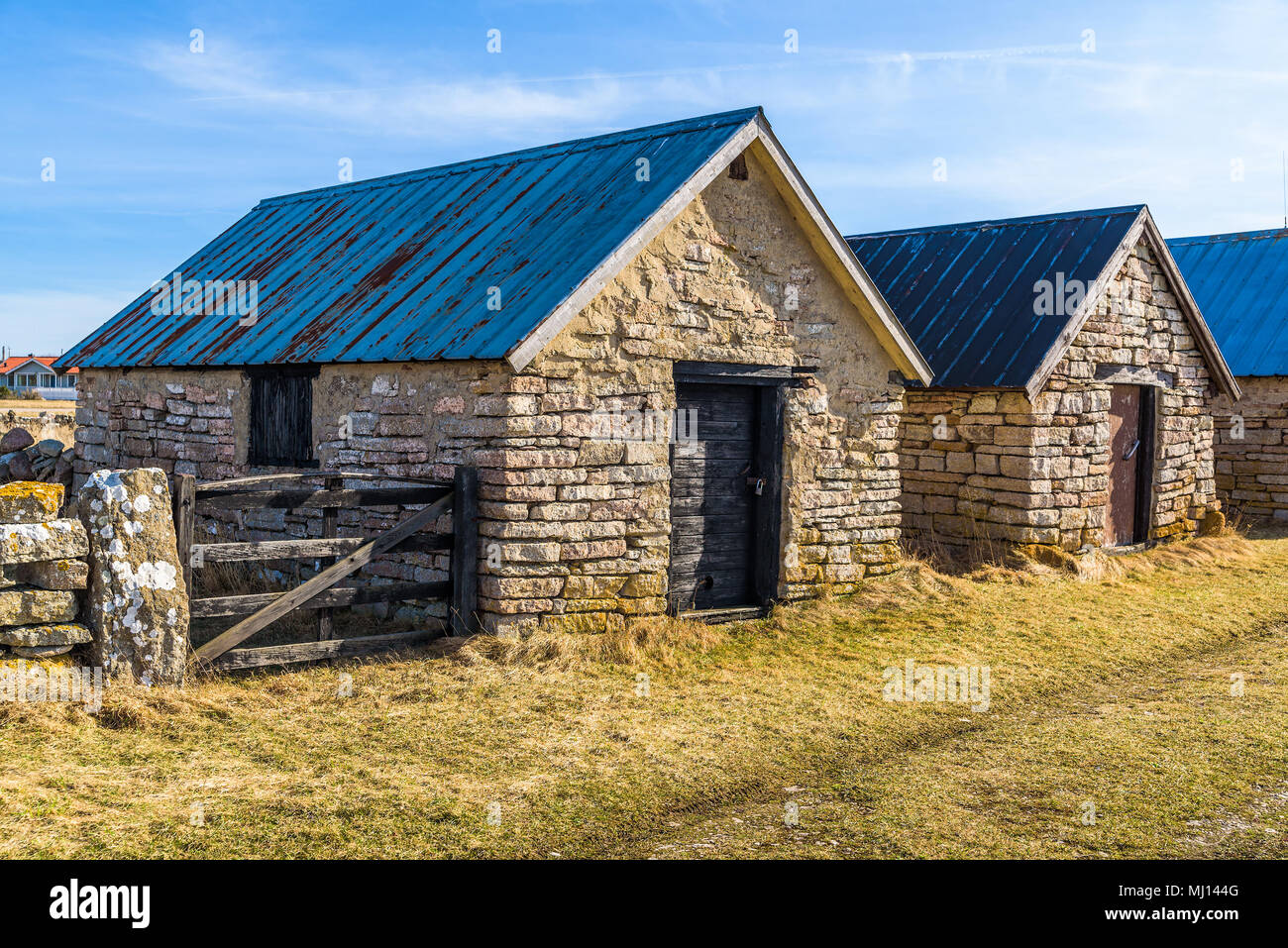 Rural limestone storage sheds and a closed gate beside one of the ...