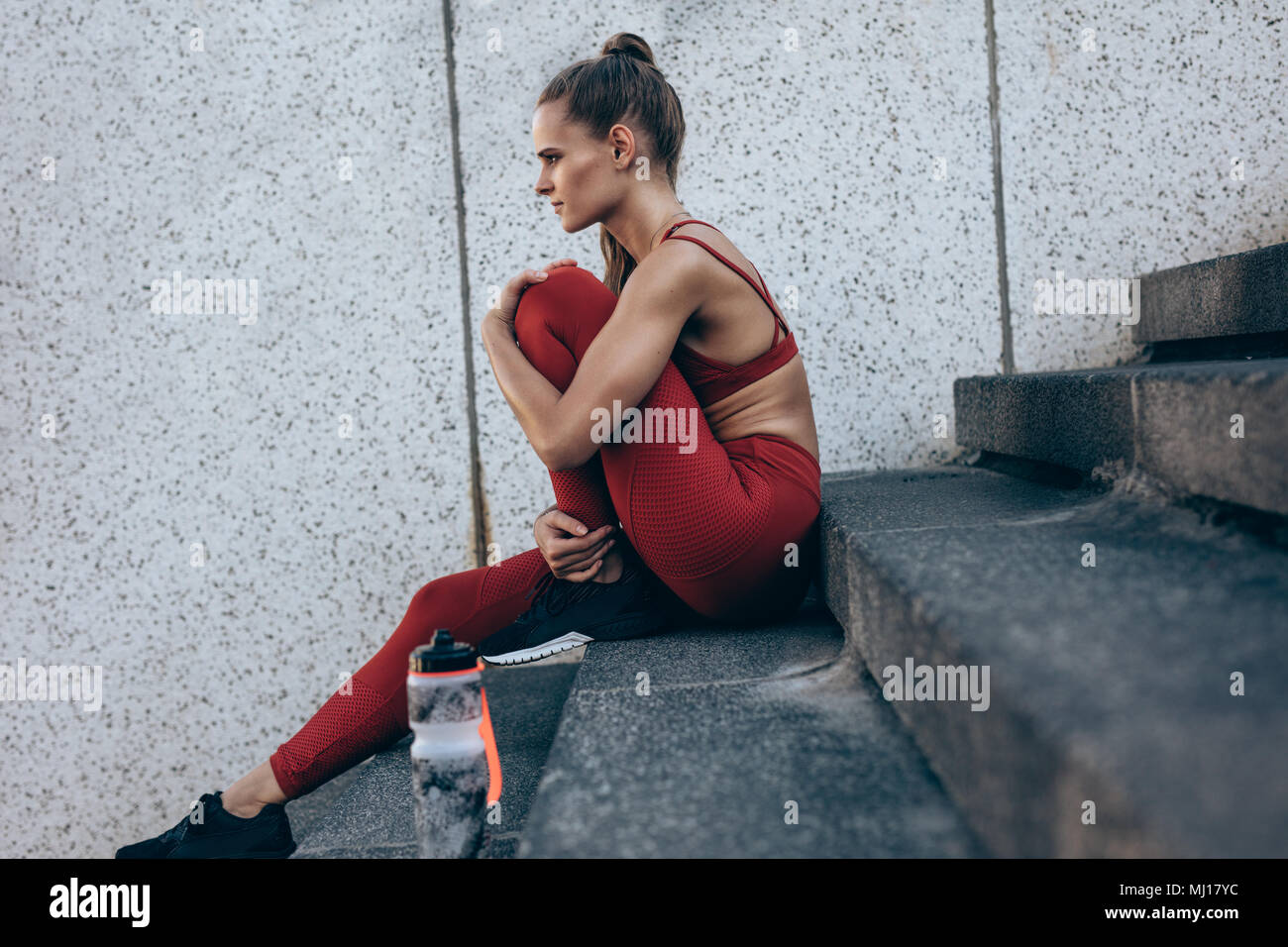 Fitness woman sitting on steps hi-res stock photography and images - Alamy