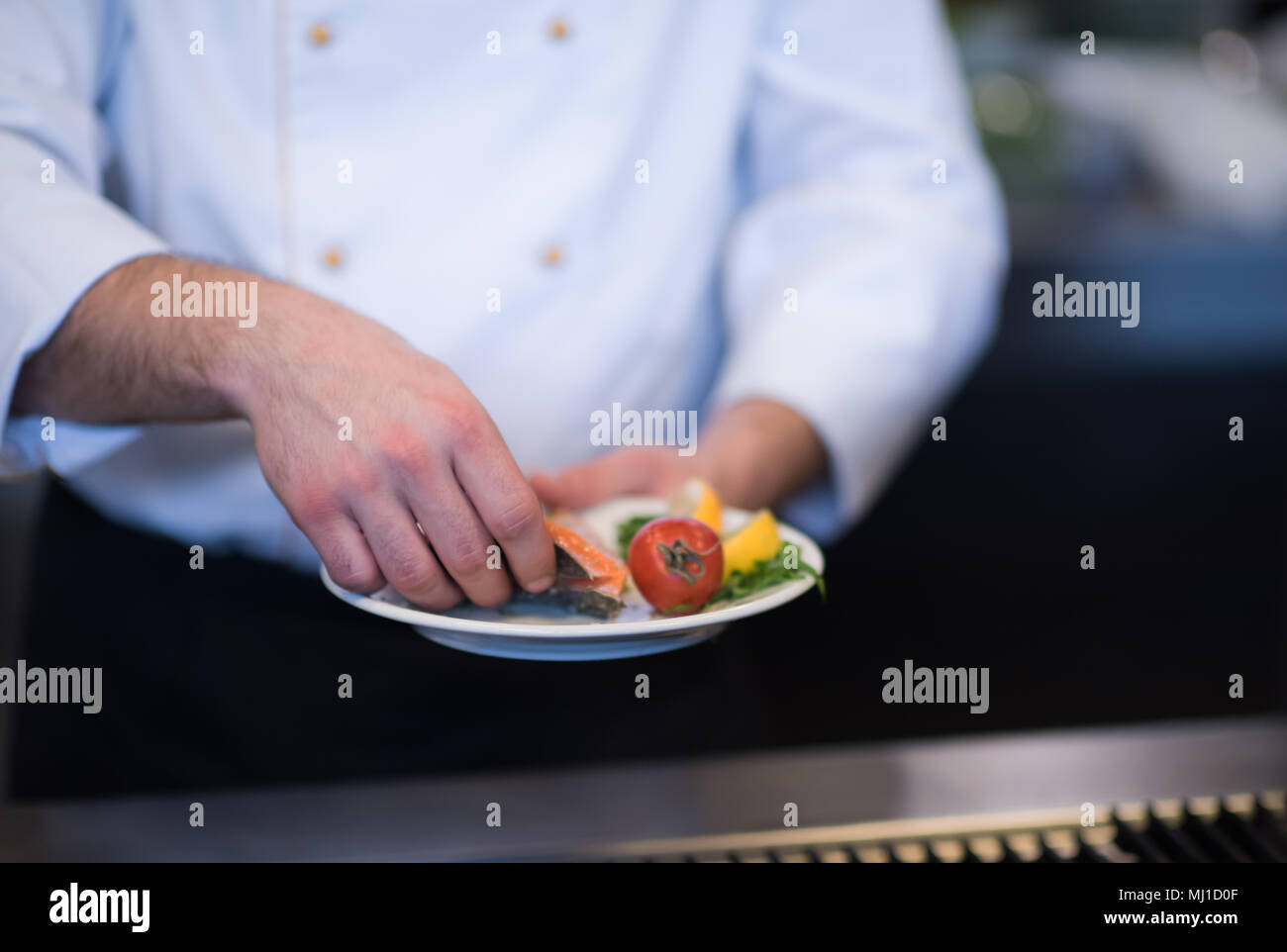 Master chef hands cooking grilled salmon fish with potatoes on a ...