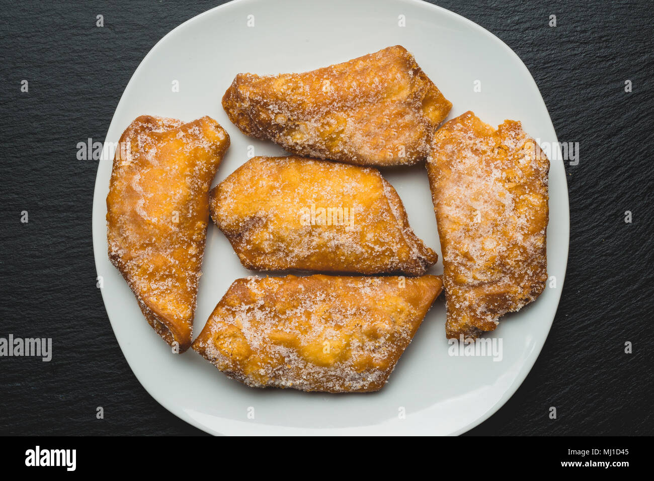 Typical spanish sweets, Fritters with sugar or pestinos Stock Photo - Alamy