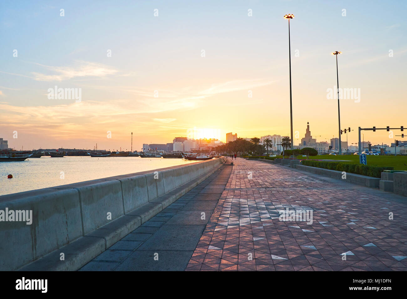The scenic sunrise over the Corniche promenade of Doha with a view on ...