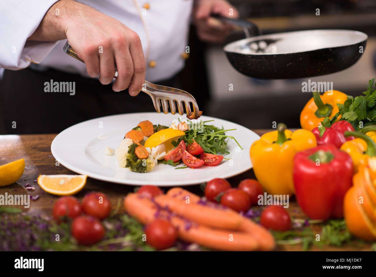 chef serving vegetable salad on plate in restaurant kitchen Stock Photo ...