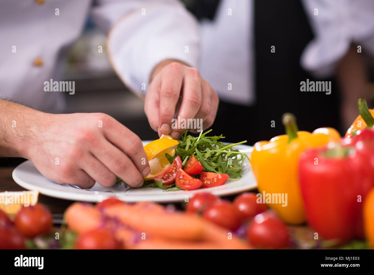 chef serving vegetable salad on plate in restaurant kitchen Stock Photo ...