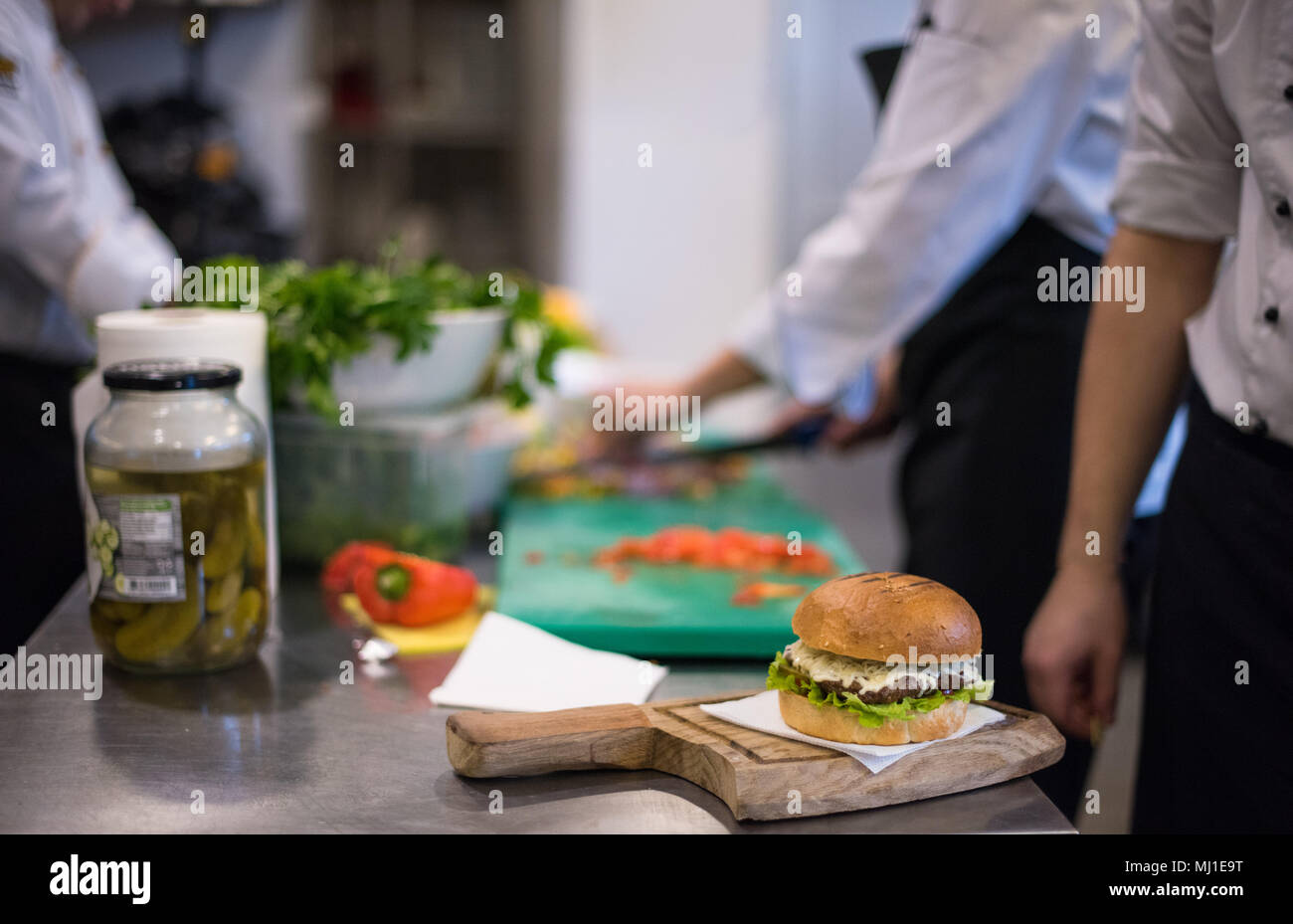 master chef putting toothpick on a burger in restaurant kitchen Stock ...