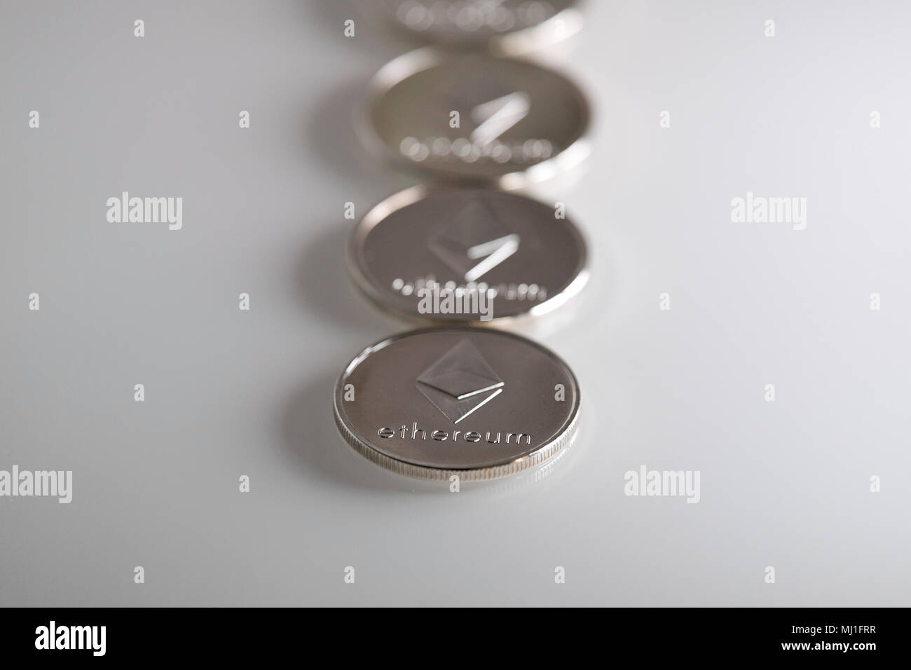 Etherium "coins" are photographed to represent cryptocurrency Etherium ...