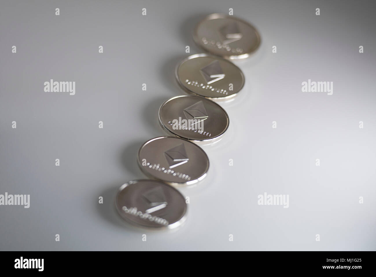 Etherium "coins" are photographed to represent cryptocurrency Etherium ...