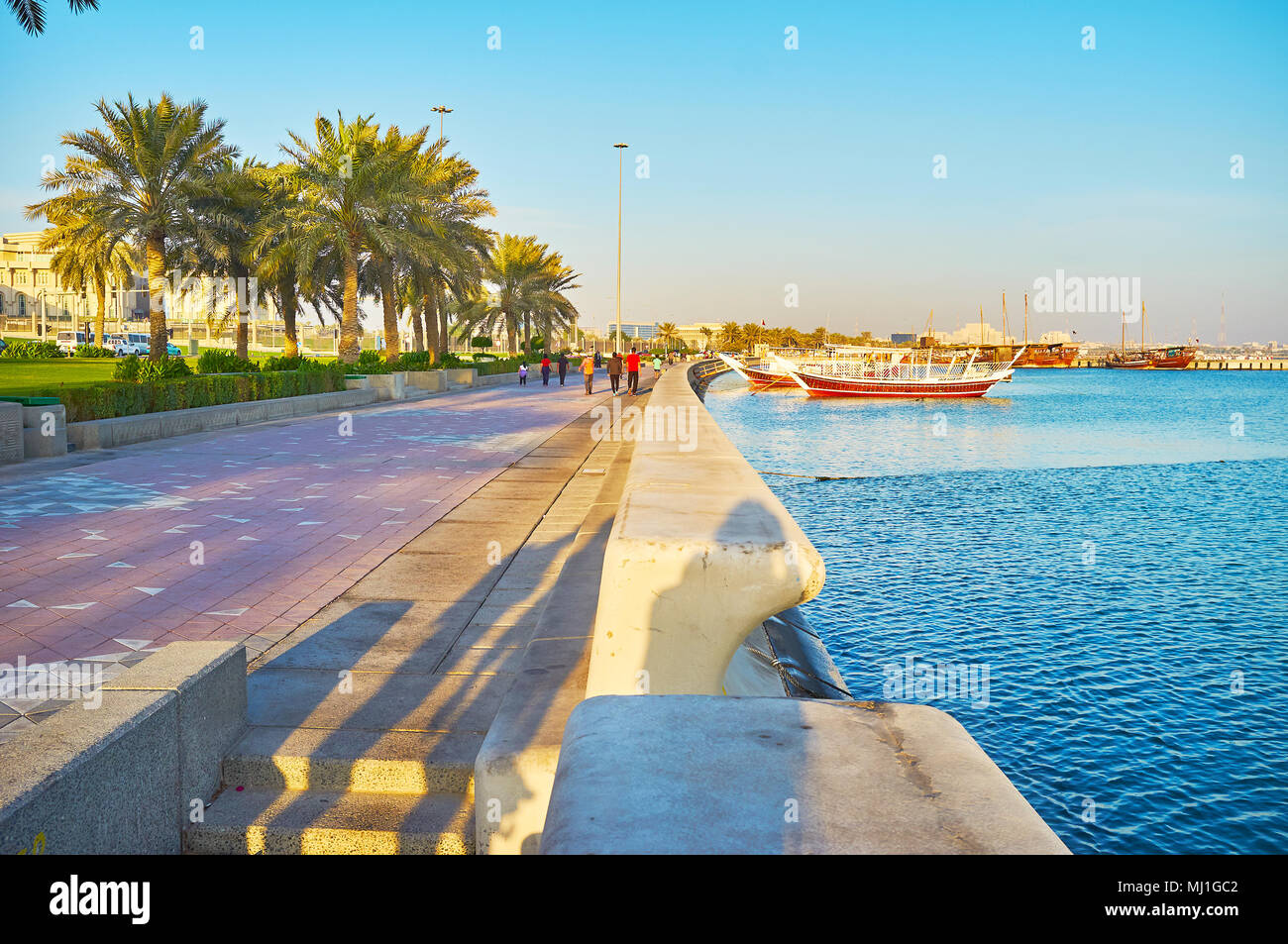 The nice seaside promenade with lush palms stretches along the shore of ...