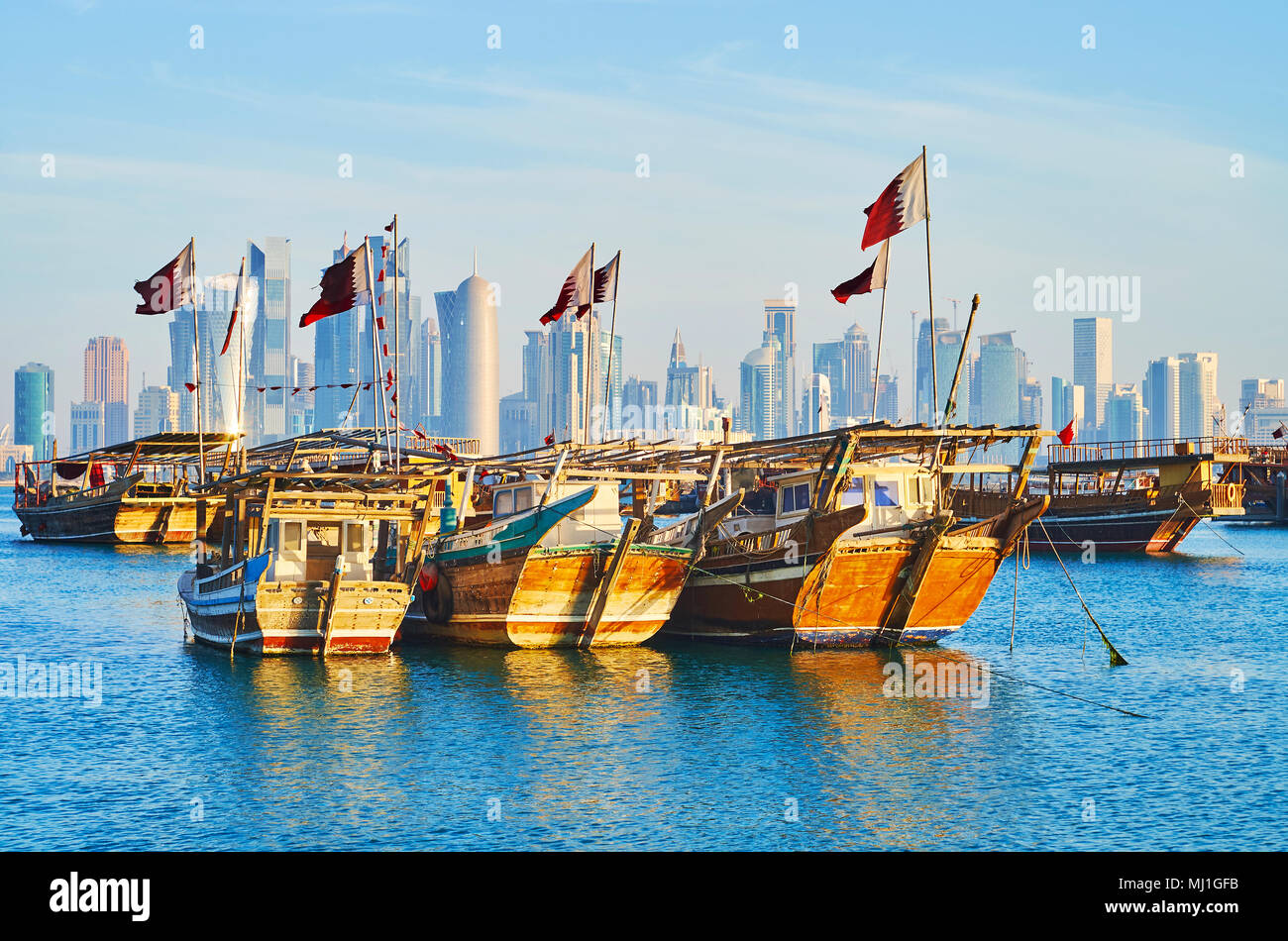 The contrast of old wooden dhows, moored in harbor and the modern ...