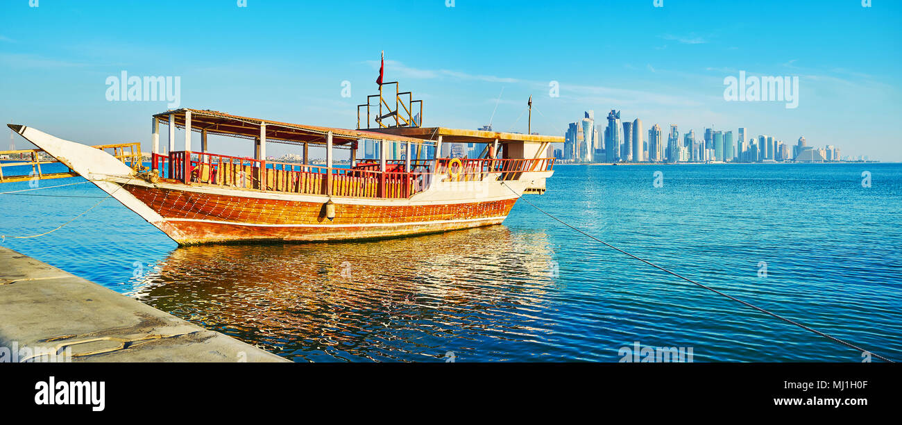 The scenic wooden dhow is reflected in rippled waters of Persian Gulf ...