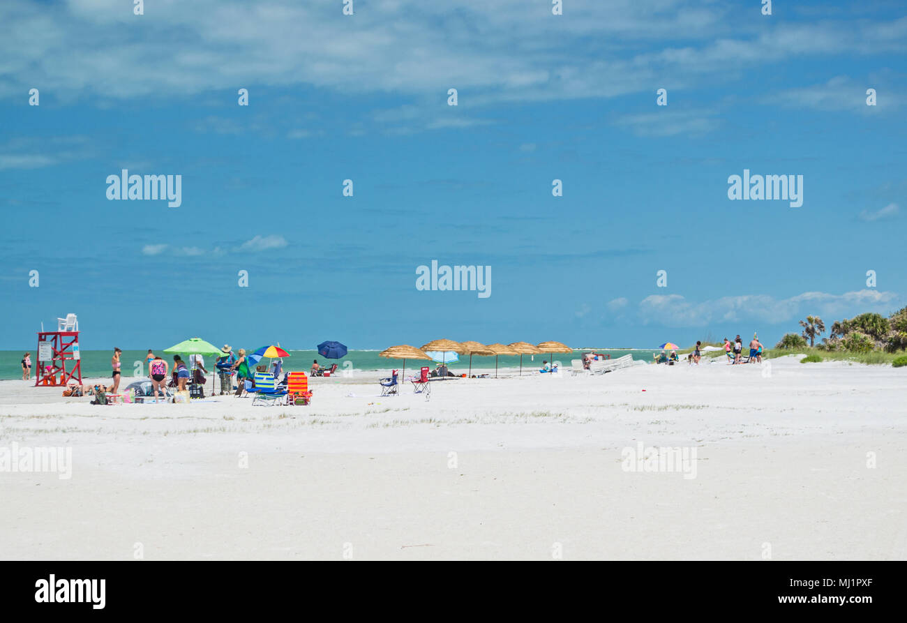 A summer day at a white sandy gulf shore Florida beach with umbrellas ...