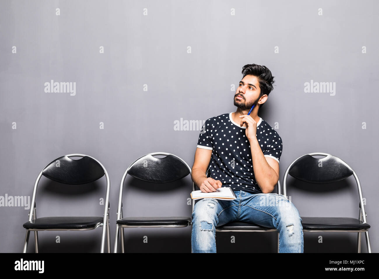 Young man in suit sitting on chair waiting for job interview Stock ...