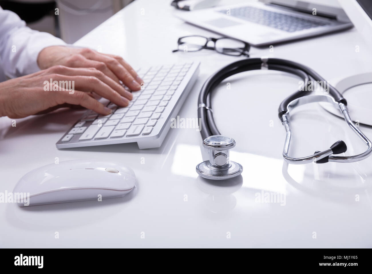 Doctor's Hand Using Computer Keyboard With Stethoscope On Desk Stock ...