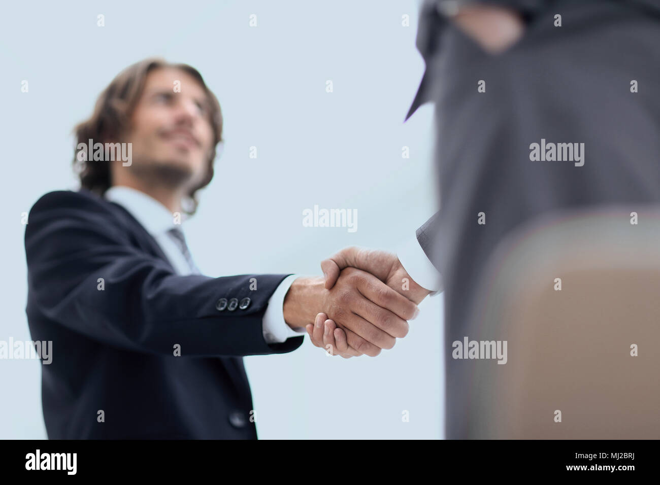 Two businessman shaking hands greeting each other Stock Photo - Alamy