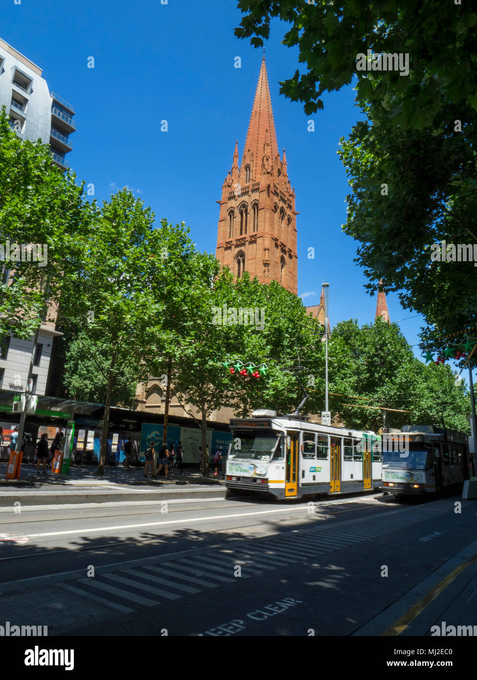 Trams travelling along Swanston Street in central Melbourne with tower ...