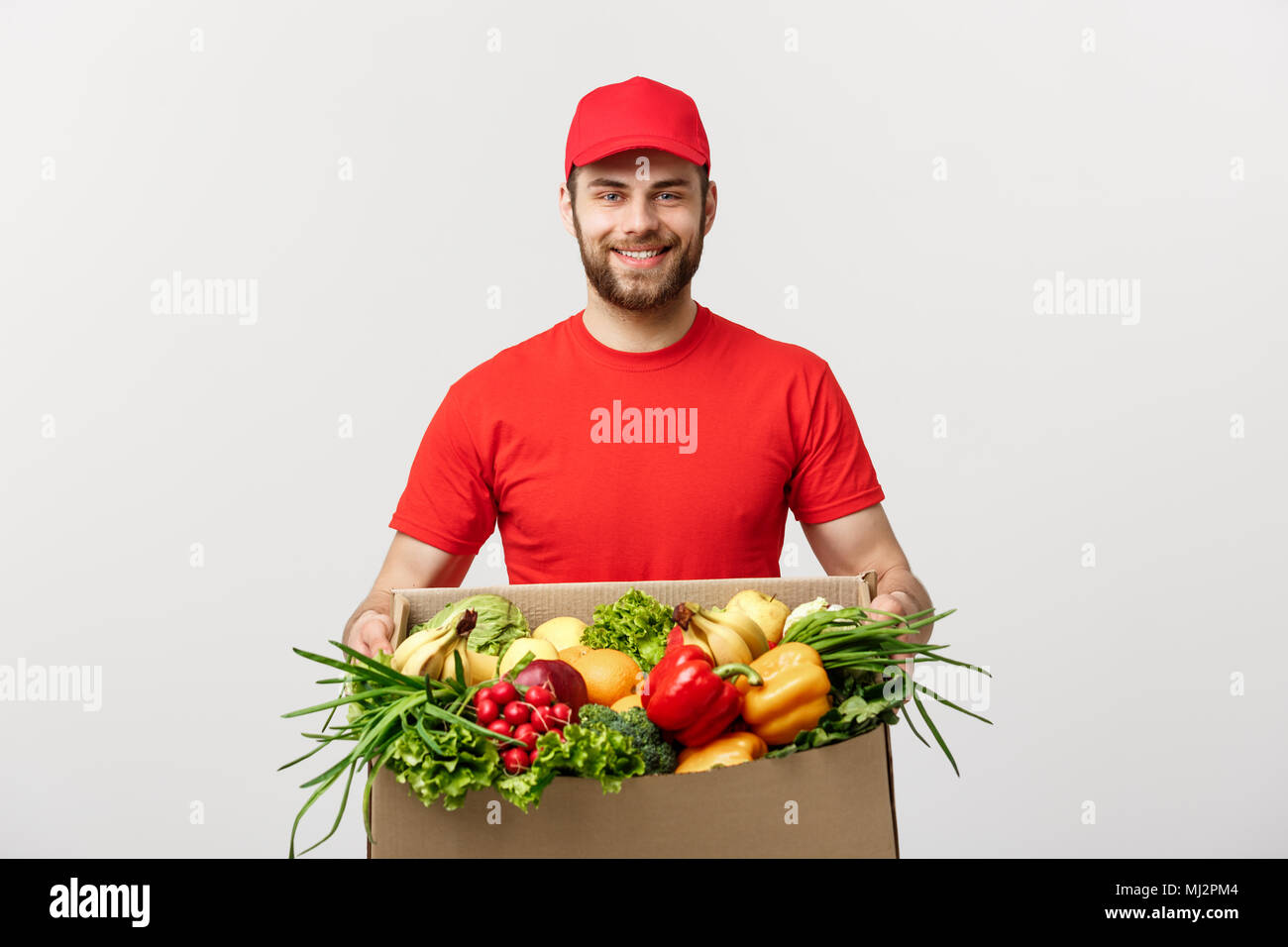 Delivery Concept - Handsome Cacasian delivery man carrying package box ...
