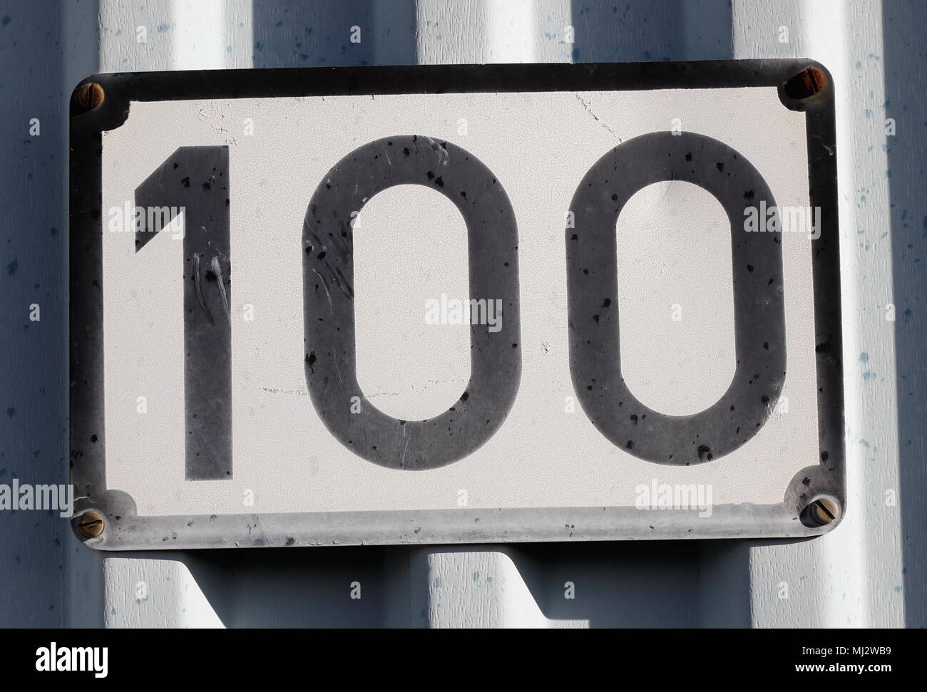 A house number faded plate with number 100 Stock Photo - Alamy
