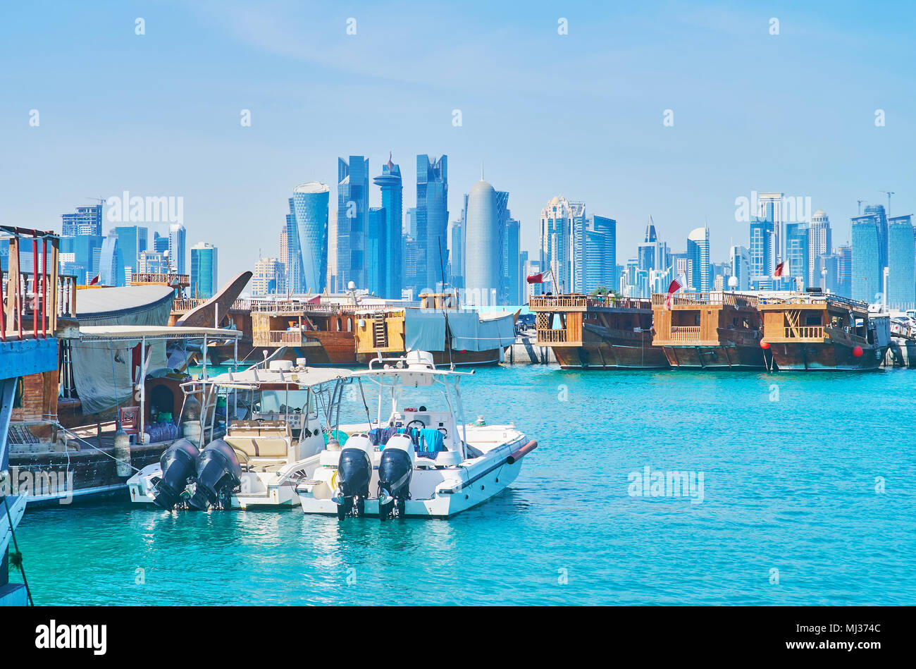 The harbor of Doha is full of traditional dhow boats, popular among ...
