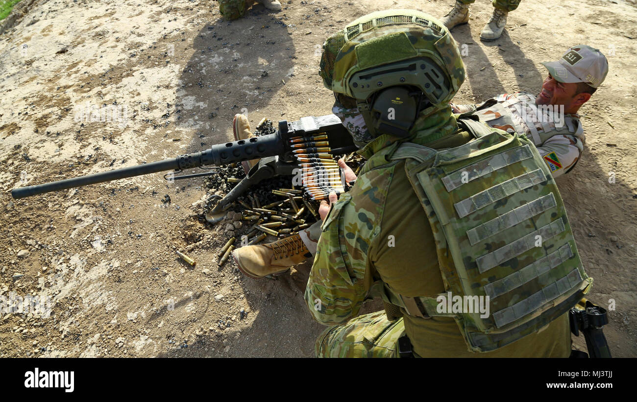 A member from the Australian army observes as an Iraqi soldier fires a ...