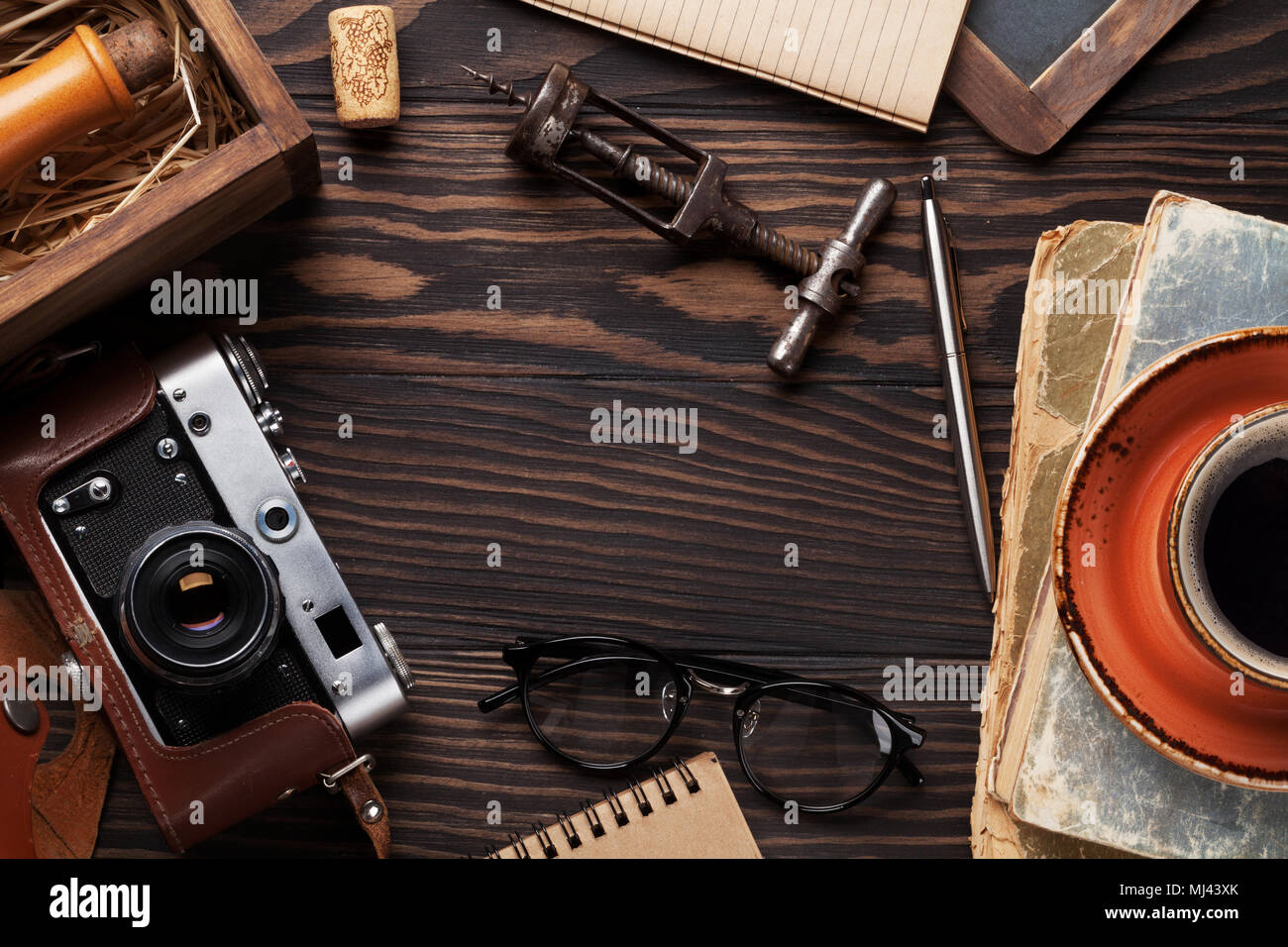Retro table with vintage items. Camera, books, notepad, wine bottle and ...