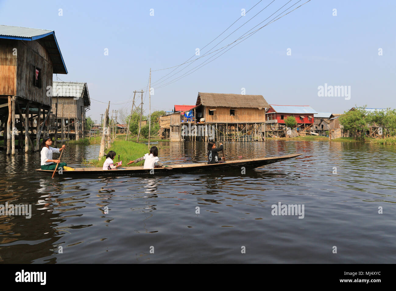 Children paddling a boat at Kayla Village at the south end of Inle Lake ...