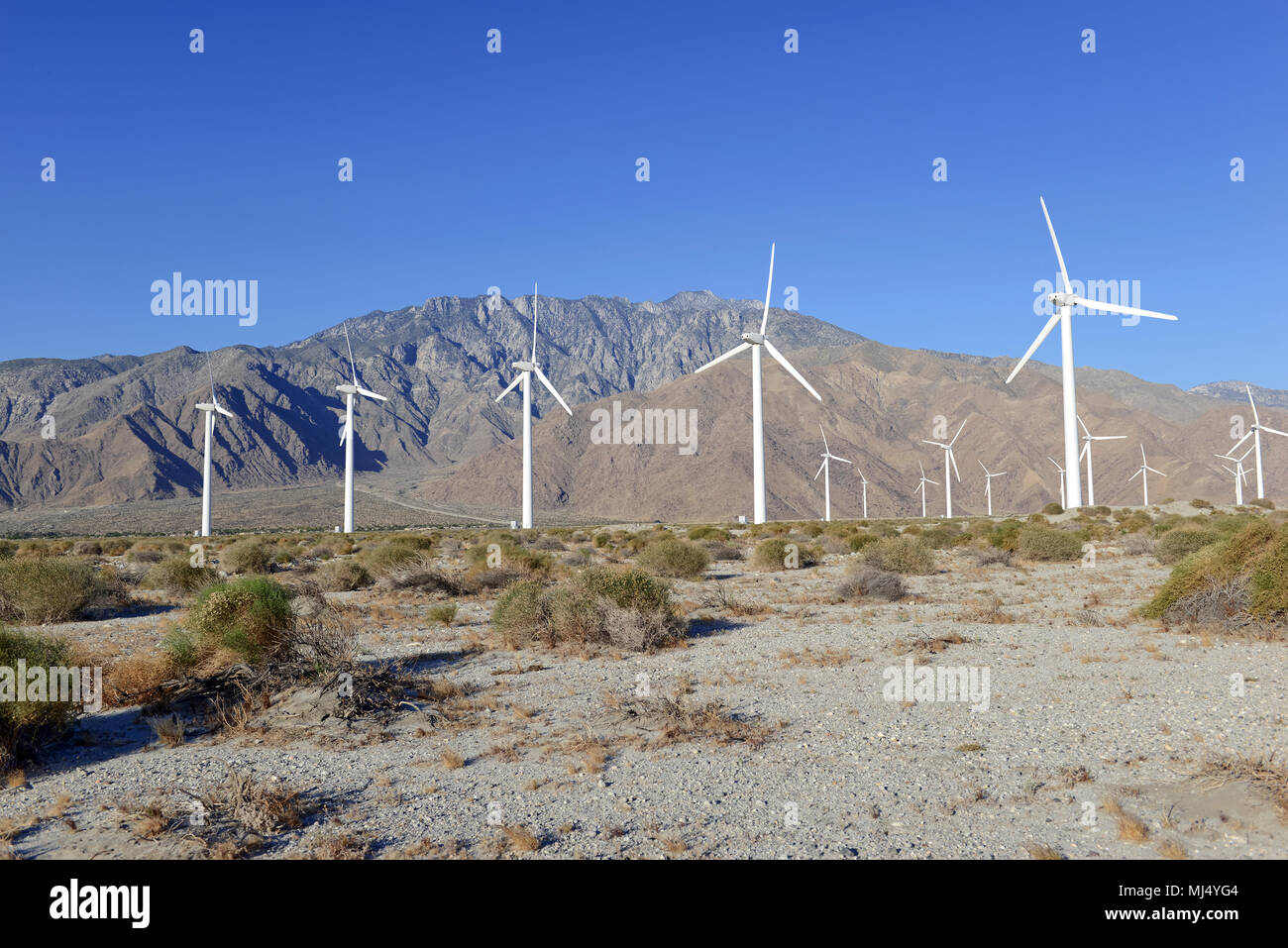 Wind turbines creating renewable energy on windfarm in desert with ...