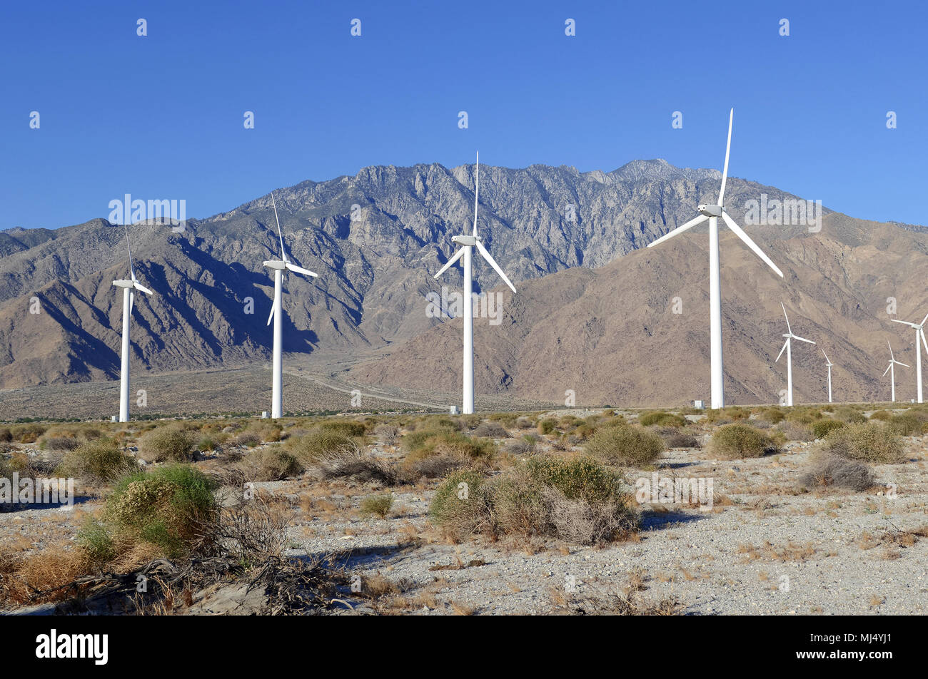 Wind turbines creating renewable energy on windfarm in desert with ...