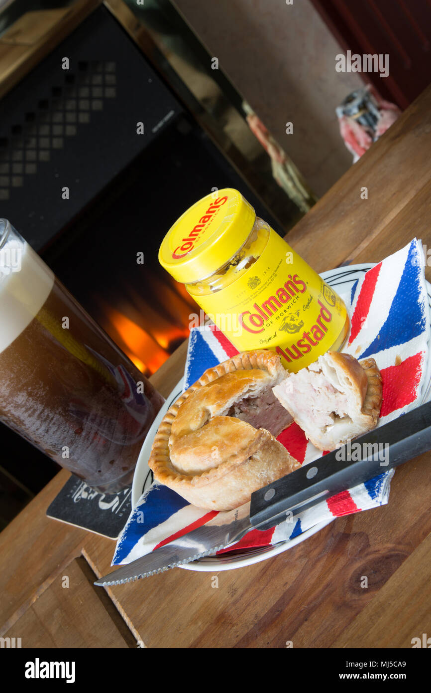 An English pub classic snack of Pork pie with Coleman's English mustard ...