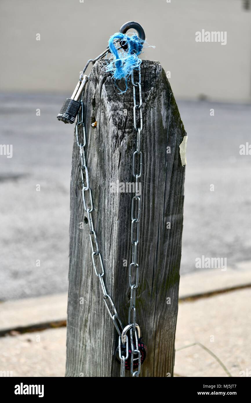 Wood post with lock, chain, and blue rope Stock Photo - Alamy