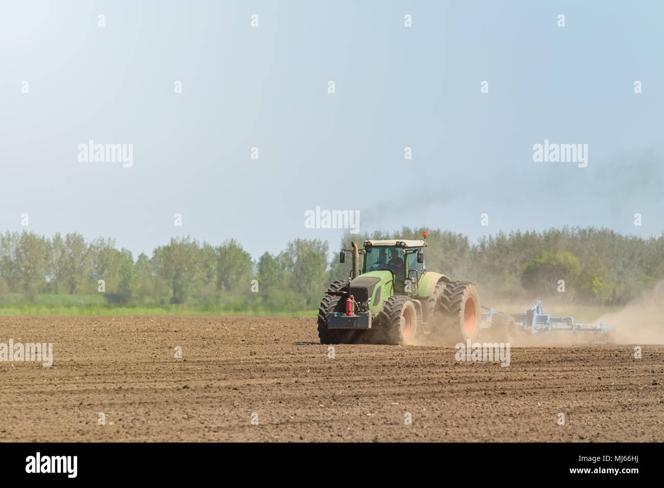 Farmer in tractor preparing land seedbed cultivator. Agriculture ...