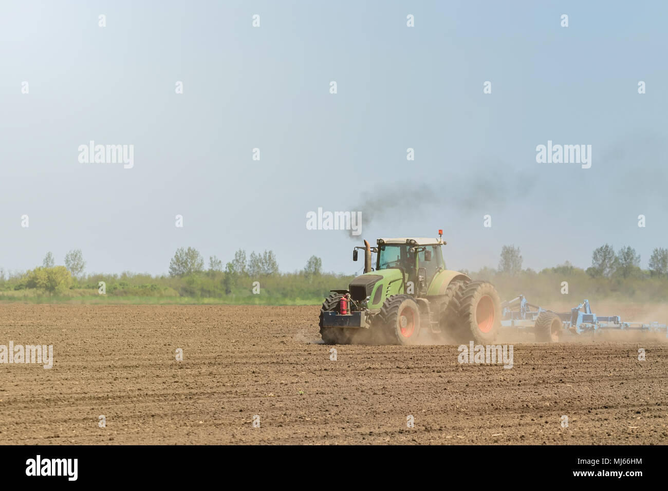 Farmer in tractor preparing land seedbed cultivator. Agriculture ...