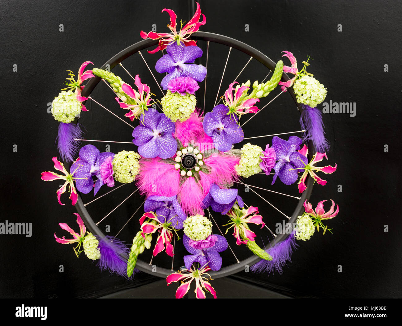 Bright flower arrangement on a wheel on a black background Stock Photo ...